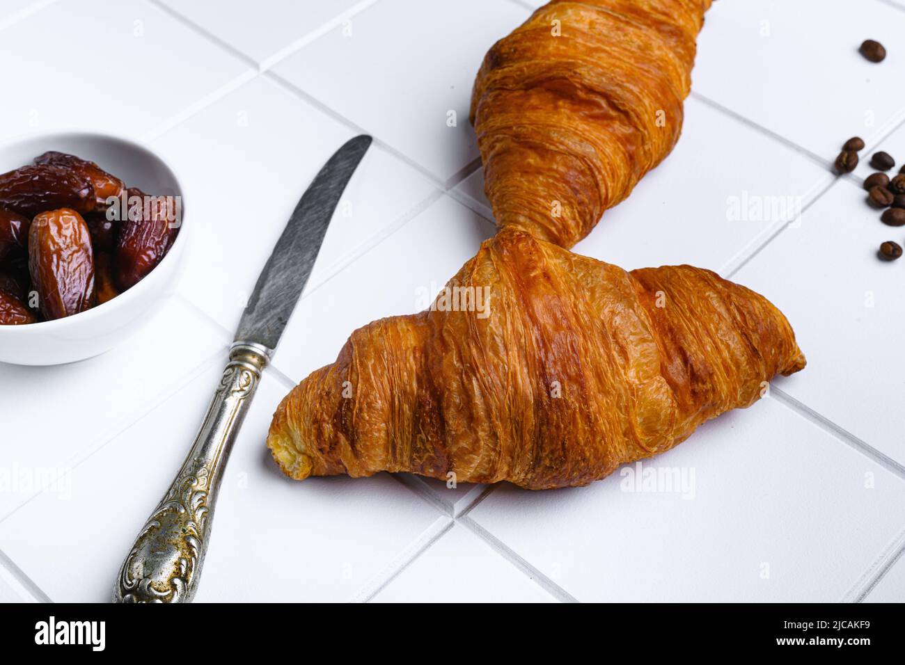 Warm butter creamy baked croissants set, on white ceramic squared tile ...