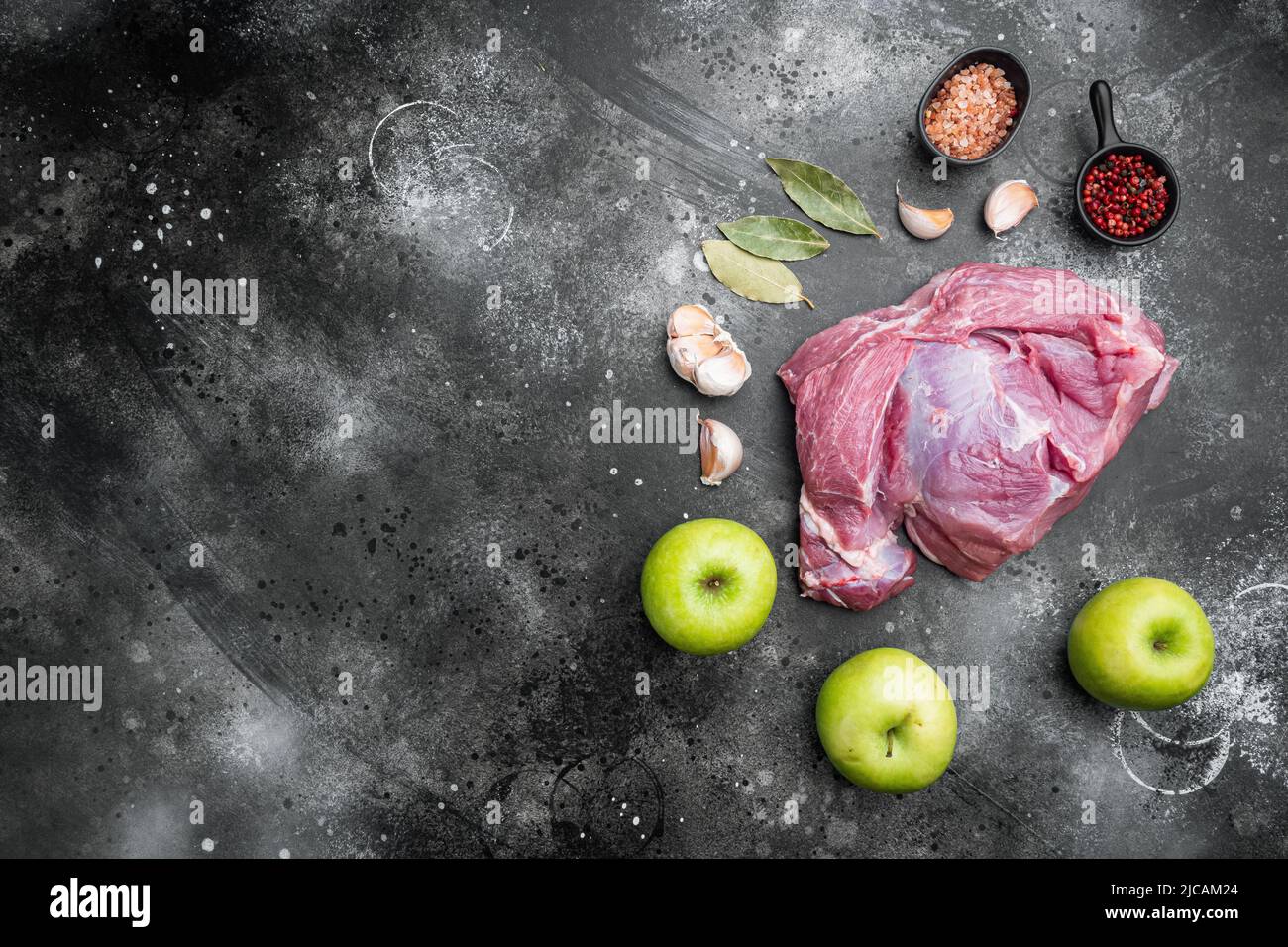 Raw slice of Iberian pork with ingredients, on black dark stone table ...
