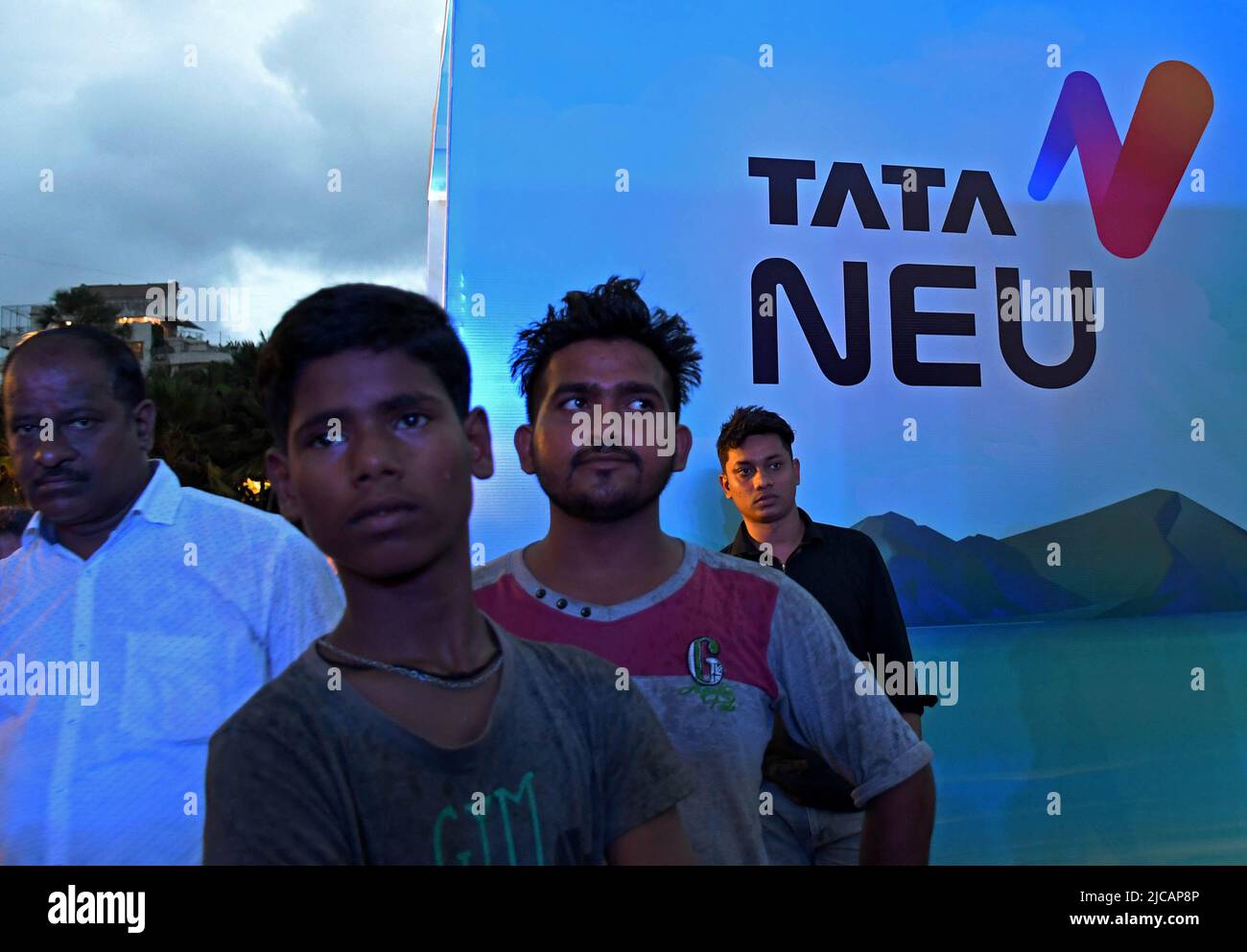 People stand next to the logo of 'Tata Neu' in Mumbai. Promotional ...
