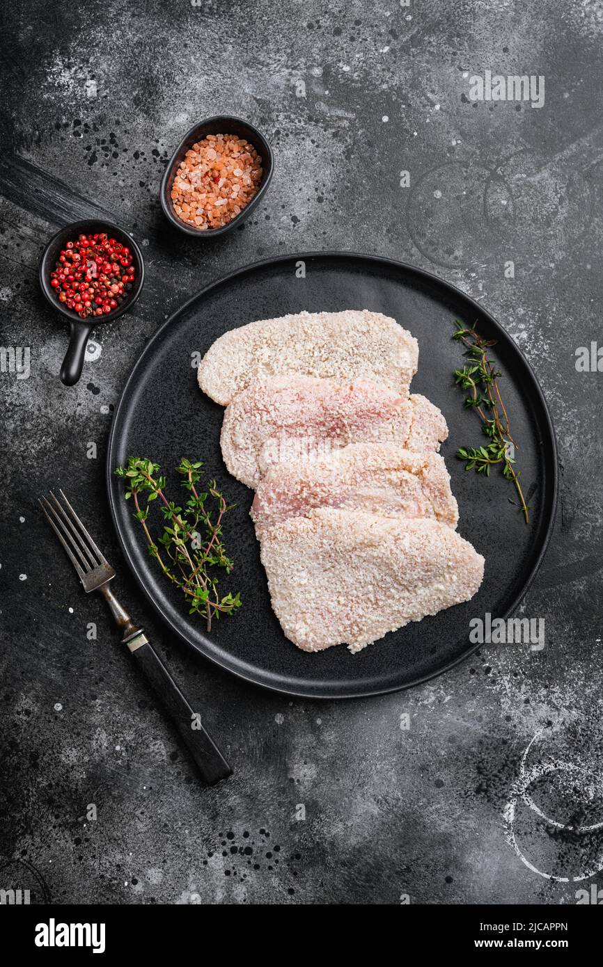 Raw schnitzel chicken meat set, on black dark stone table background ...