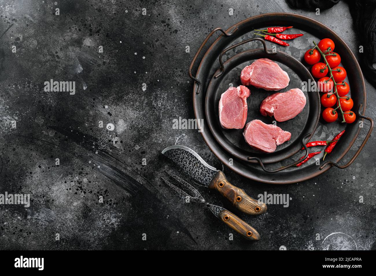 Pork tenderloin. Fresh raw meat prepared for cooking set, on black dark ...