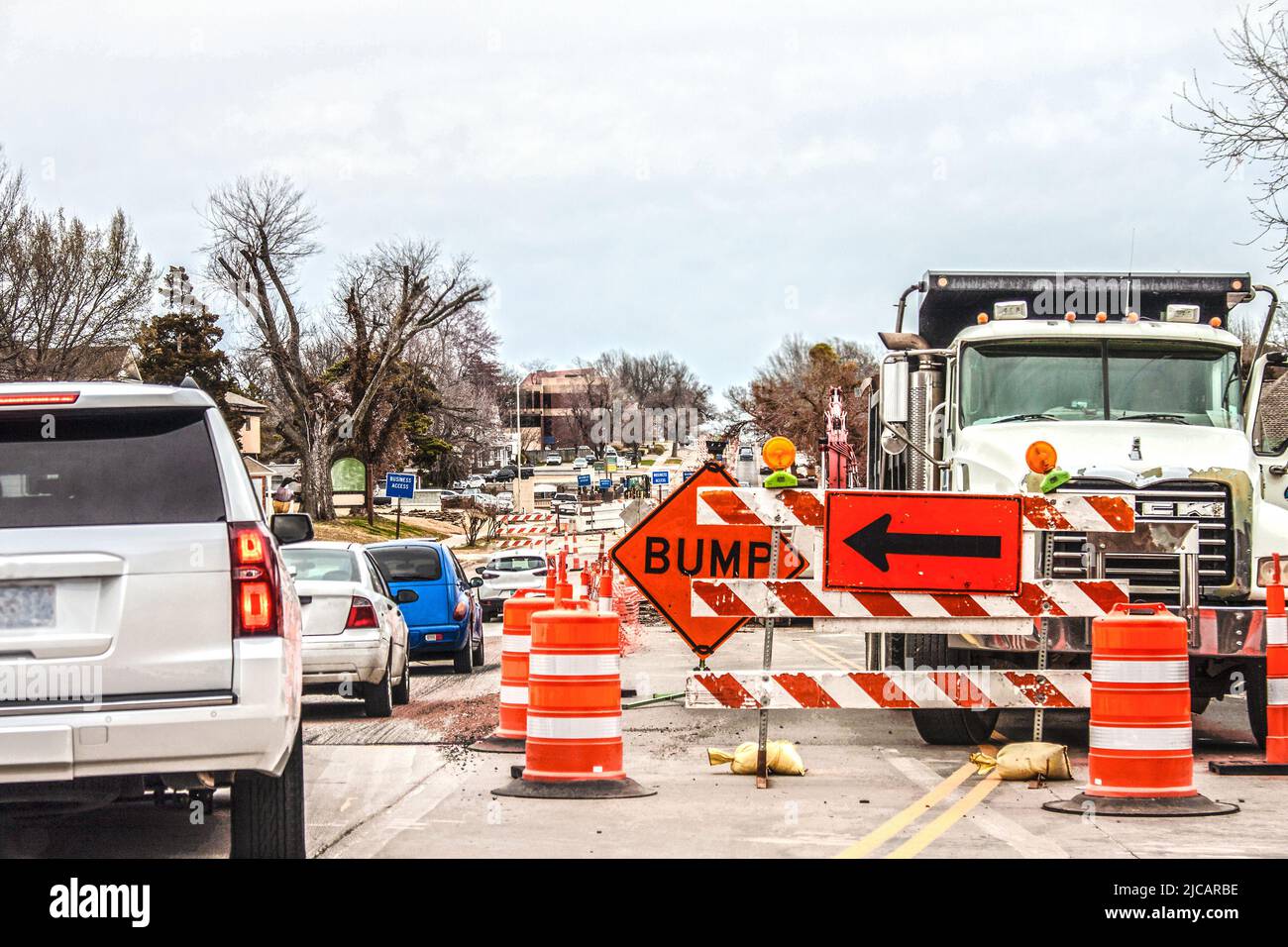 Trucks and road equipment on road with one lane blocked to horizon in ...