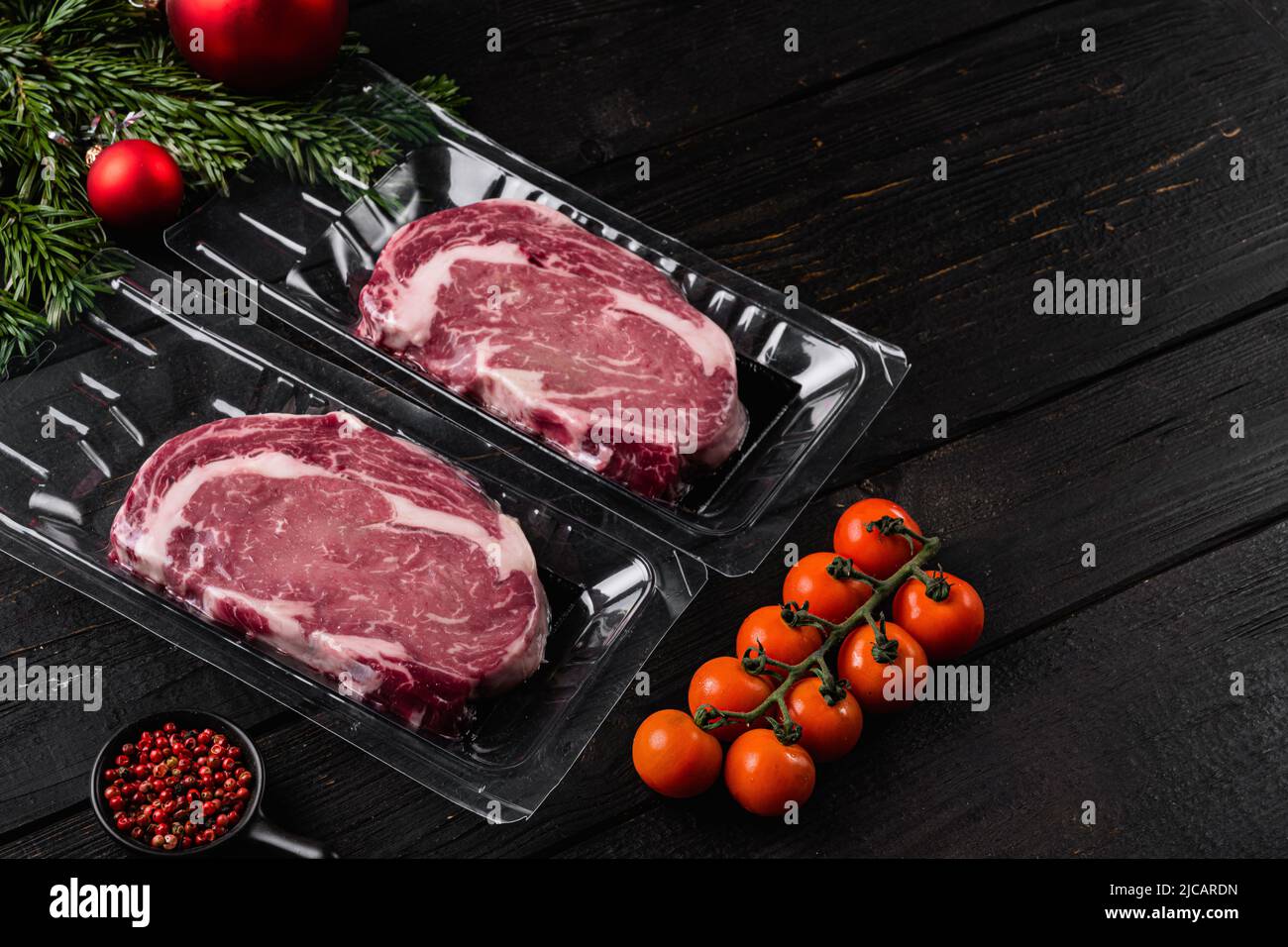 Meat in a package, on black wooden table background, with copy space ...
