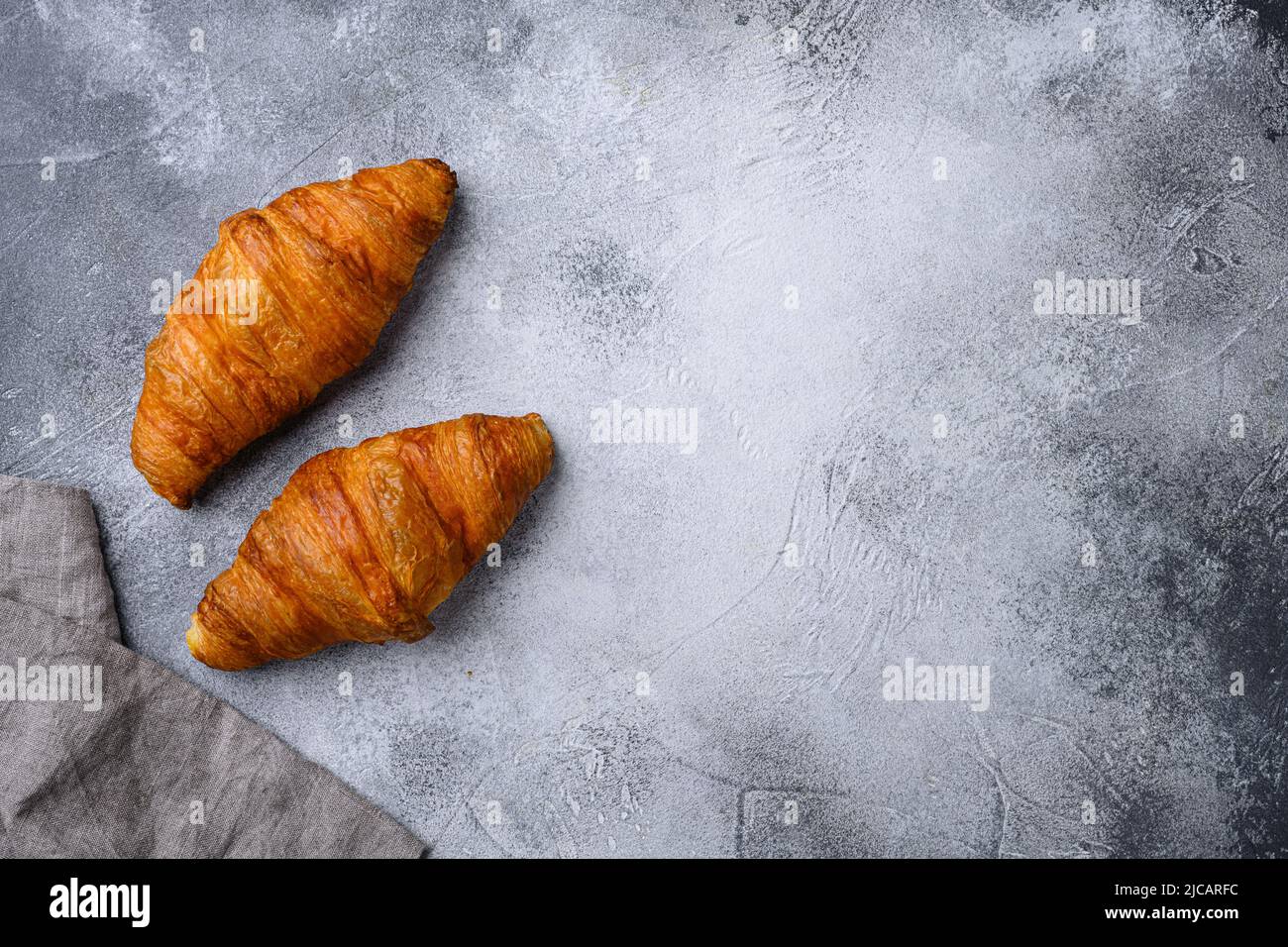 Fresh croissants on table set, on gray stone table background, top view ...