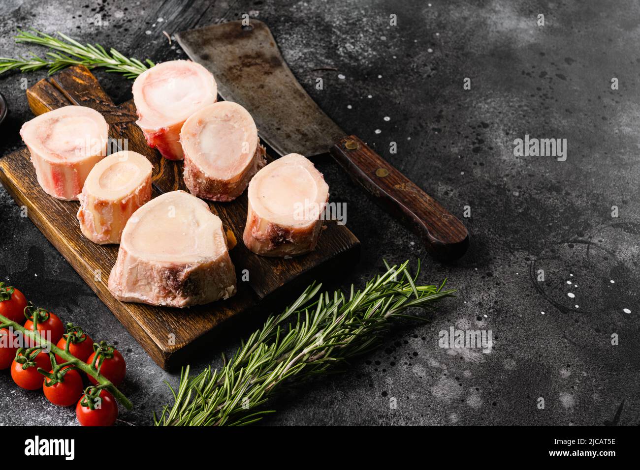 Raw caw bones butcher cut, on black dark stone table background, with ...