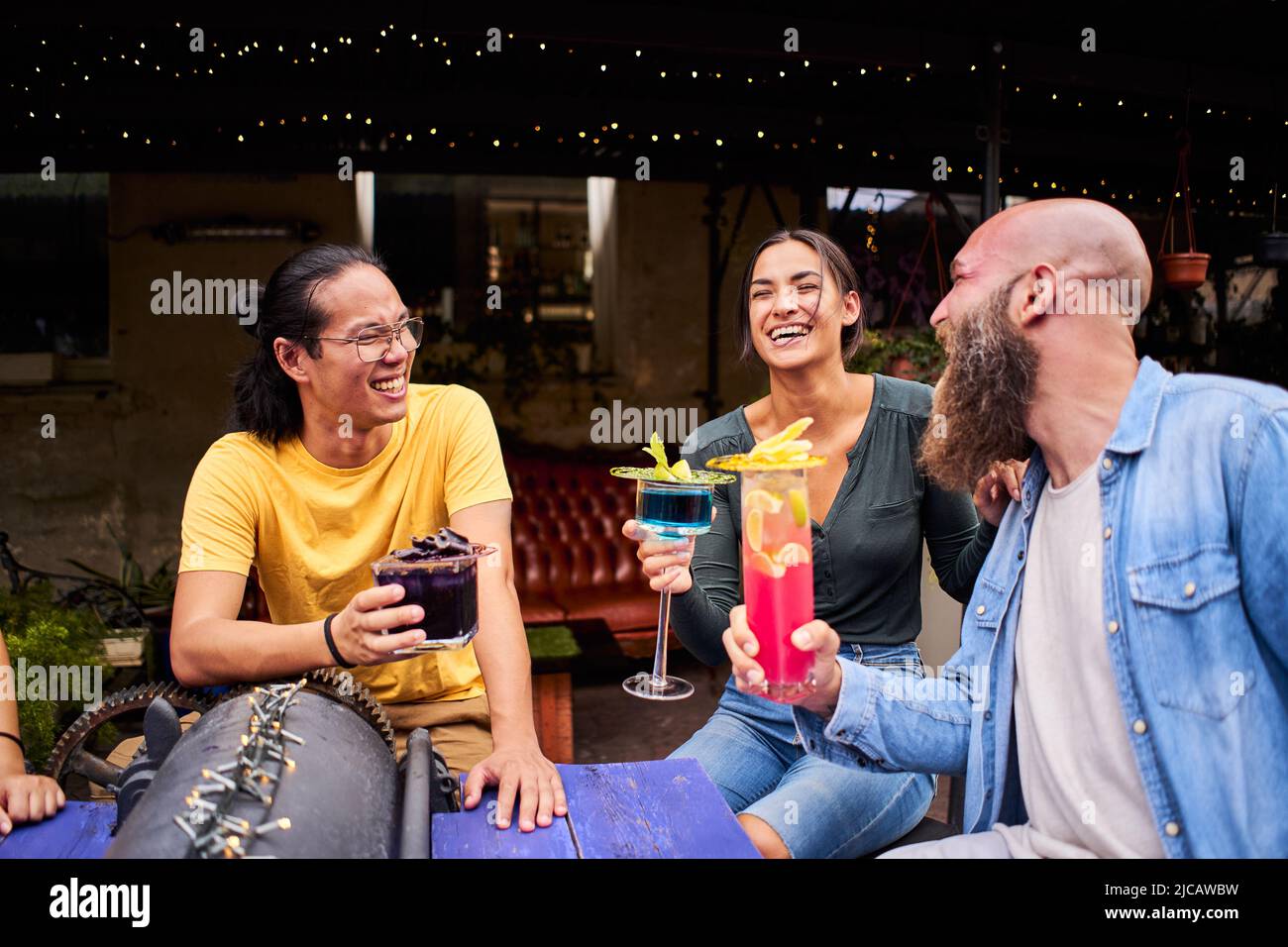 Three Friends toasting, saying cheers holding tropical blended fruit ...