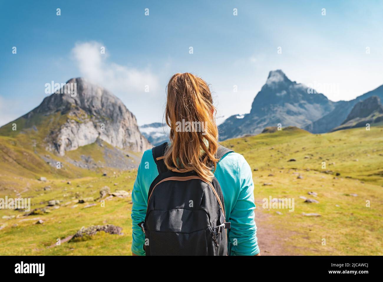 Young Attractive Woman With A Backpack hiking in a beautiful valley ...