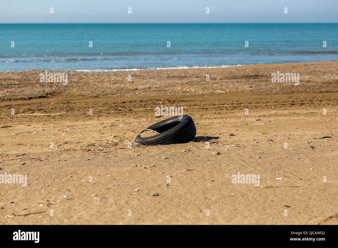 Environmental pollution on beaches. Plastic pollution, automobile tire ...