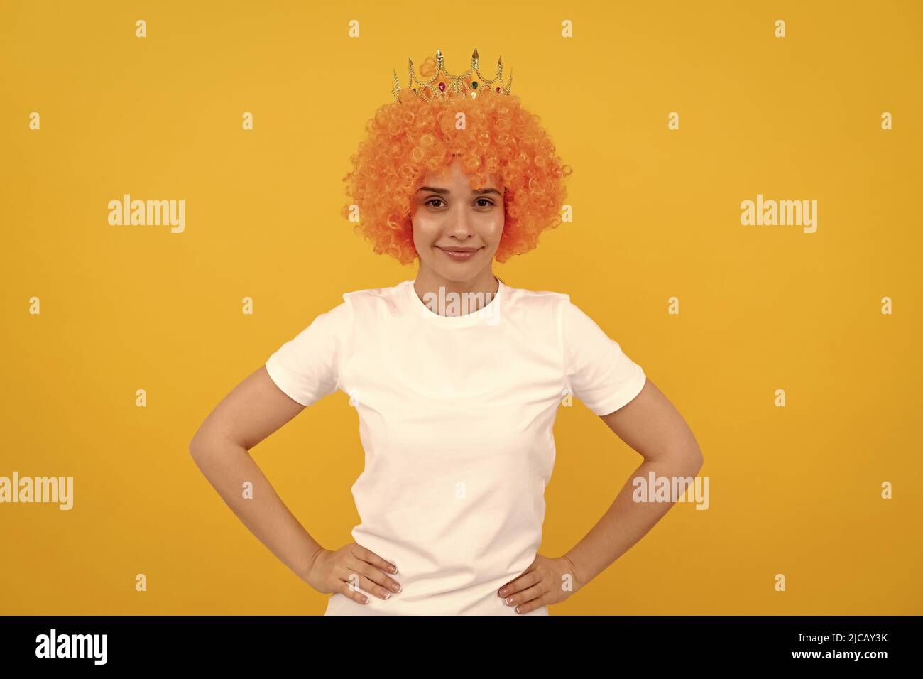cheeful freaky selfish woman in curly clown wig and queen crown for ...