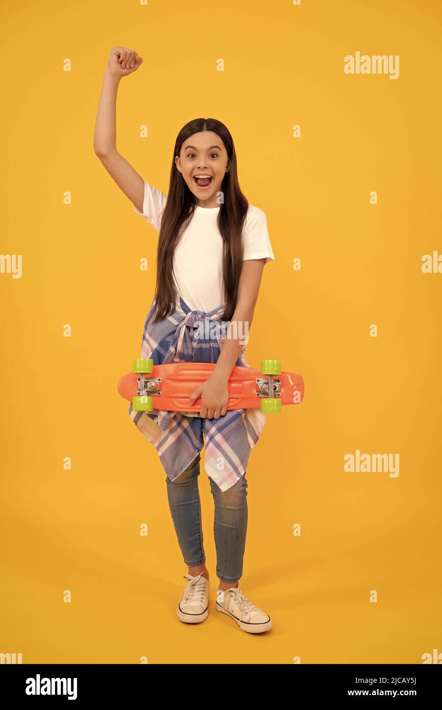 Excited girl with pennyboard happy screaming making winning gesture ...