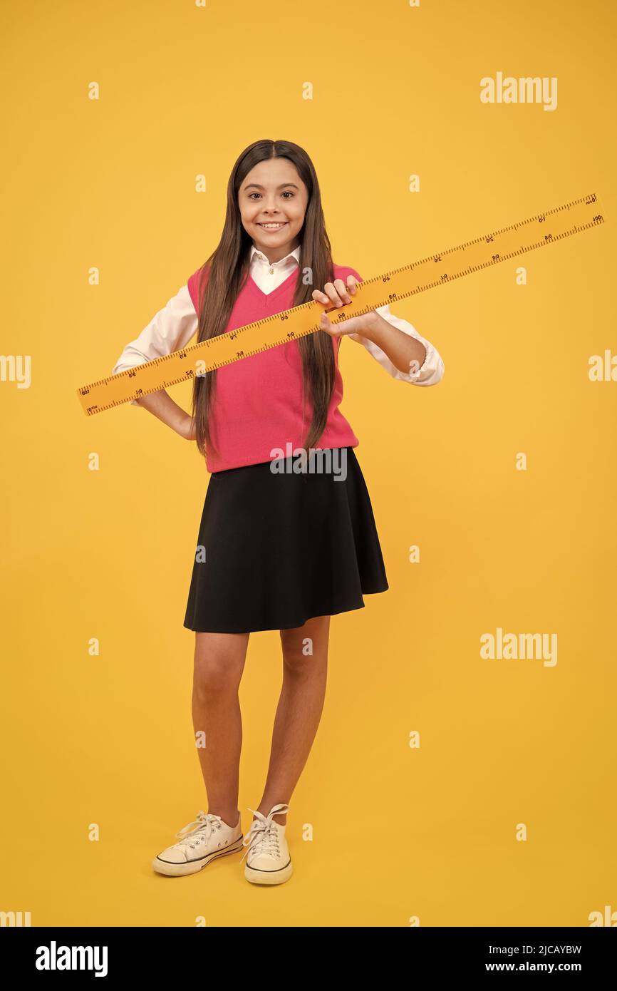 cheerful teen girl study math with ruler measuring size, back to school ...