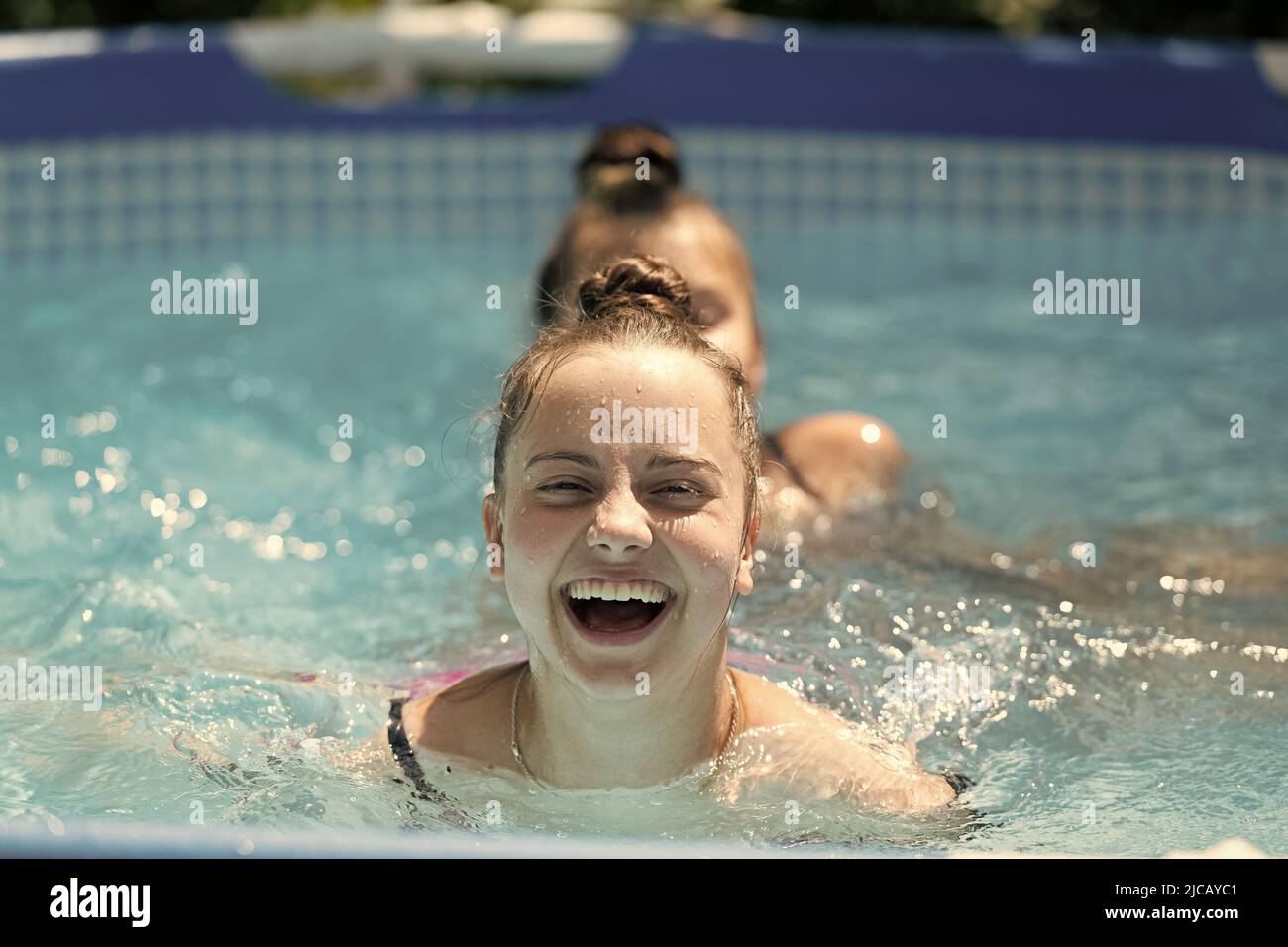 Happy children swim in swimming pool on sunny summer day, summertime ...