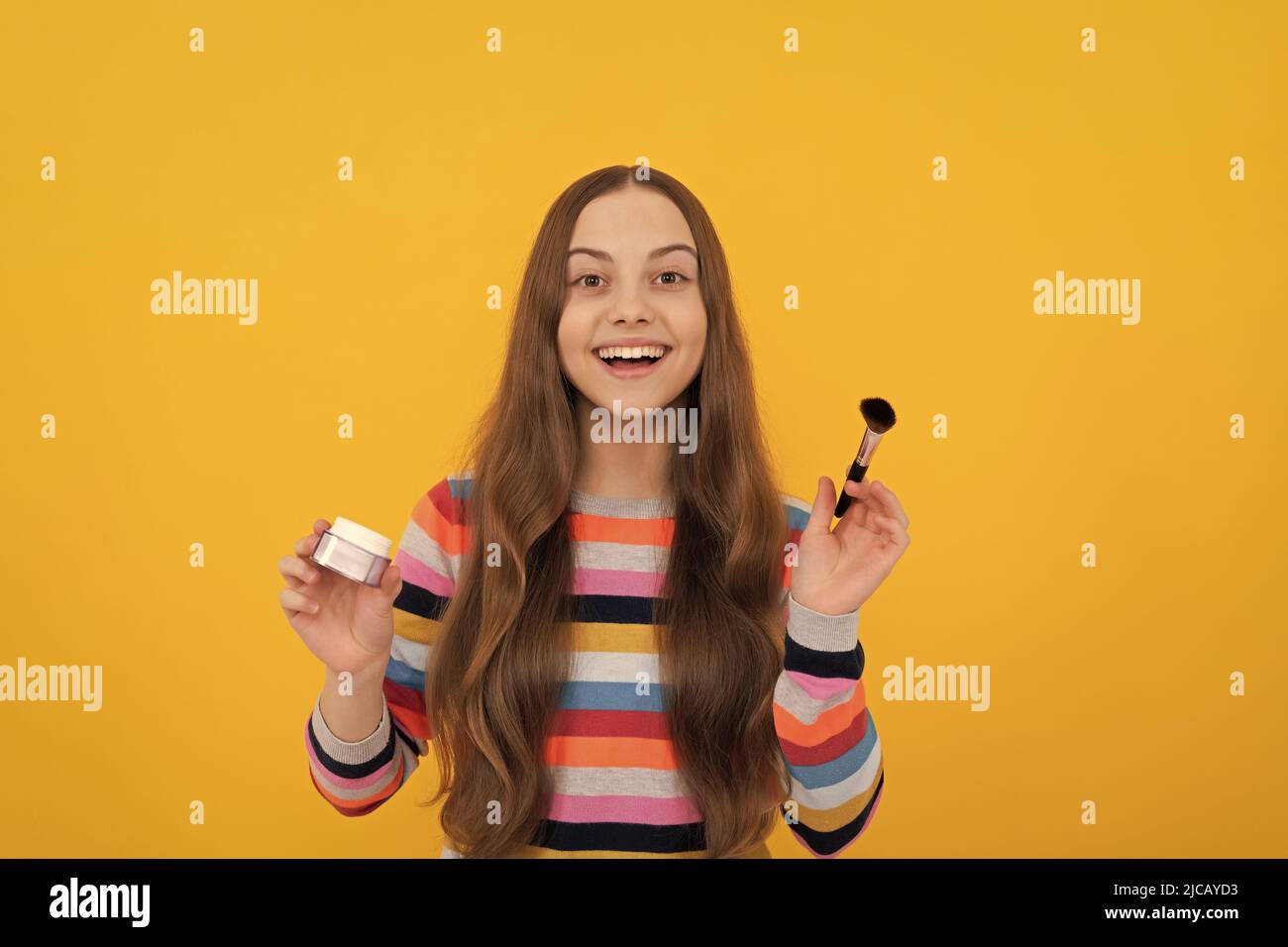 I love changing my makeup. Happy child apply cosmetics. Girl smile ...