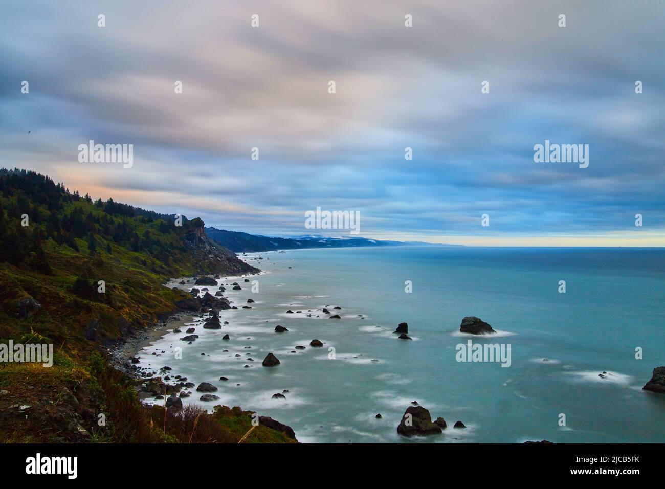 Ocean coastline during an overcast sunset with soft colors Stock Photo ...