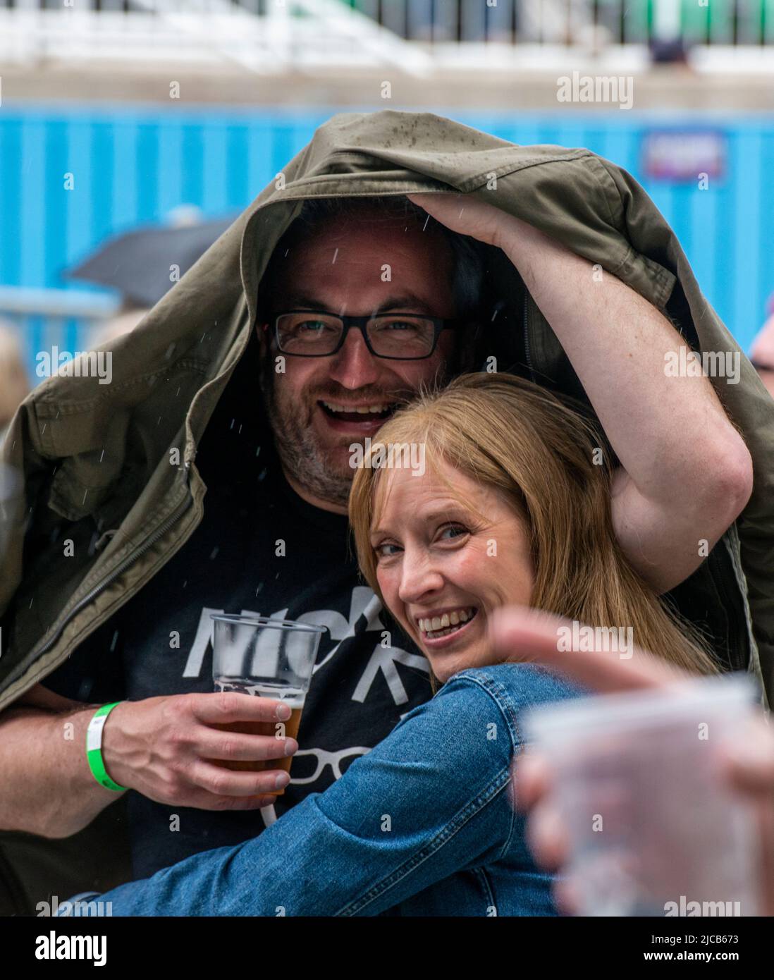 Scarborough, UK. 11th June, 2022. Crowded House fans shelter from a ...