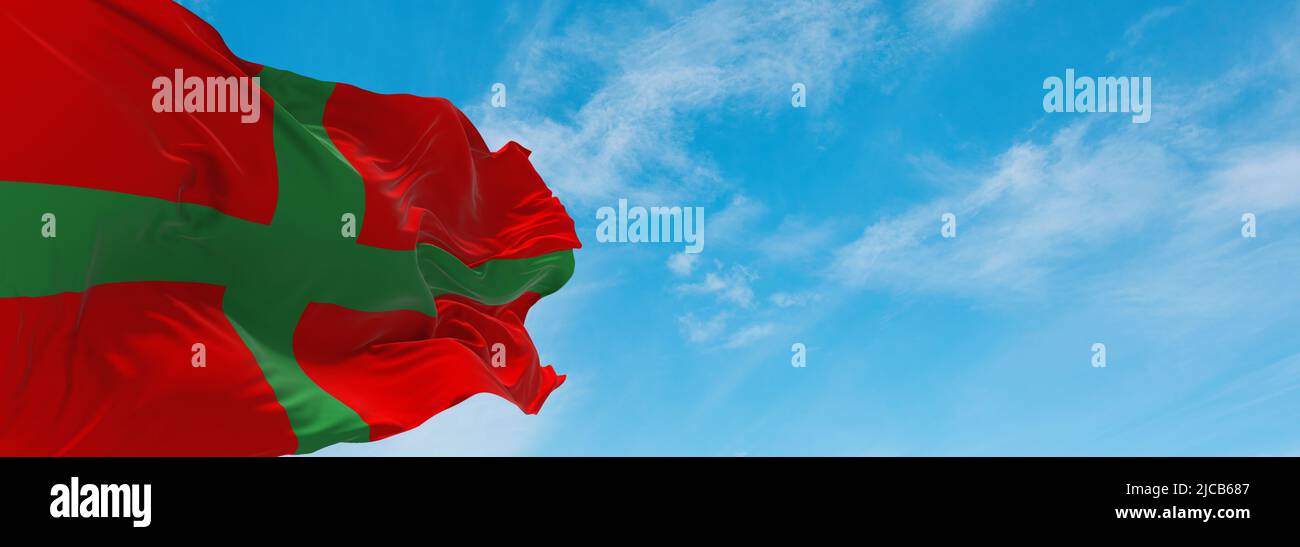 official flag of Bornholm , Denmark at cloudy sky background on sunset ...