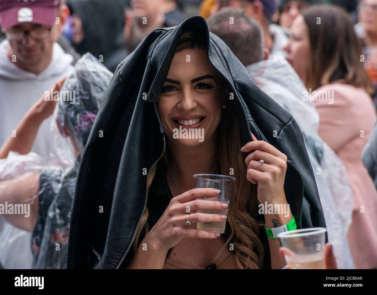 Scarborough, UK. 11th June, 2022. Crowded House fans shelter from a ...