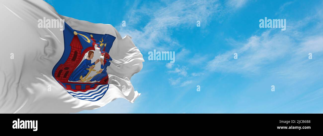 official flag of Aarhus , Denmark at cloudy sky background on sunset ...