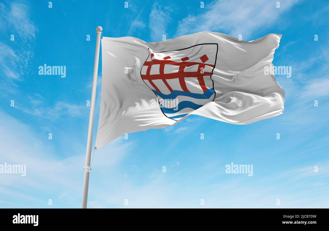 official flag of Haderslev Kommune , Denmark at cloudy sky background ...