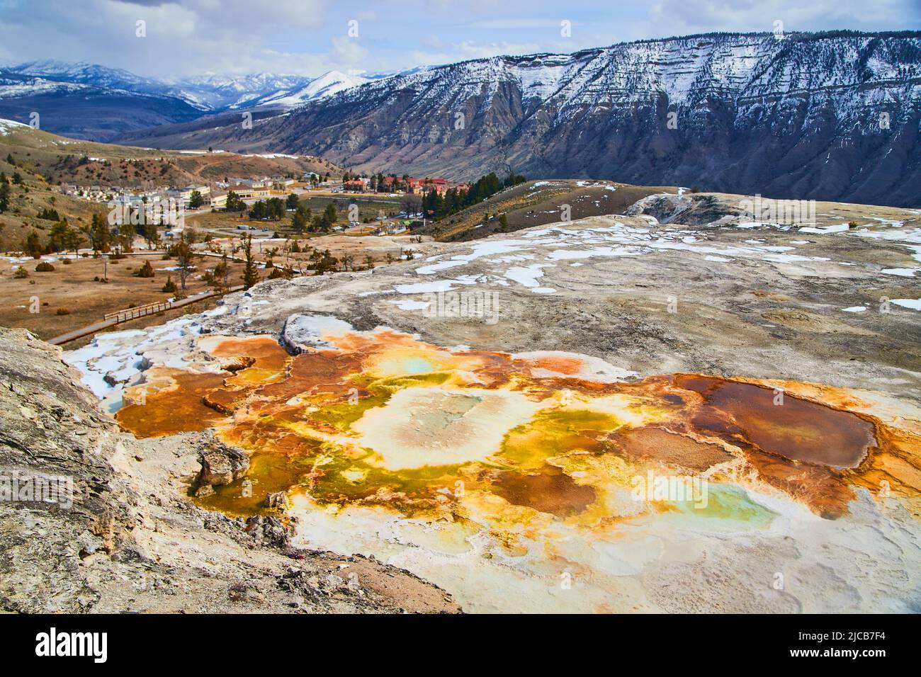 Stunning Yellowstone terraces in valley of snow-covered mountains Stock ...