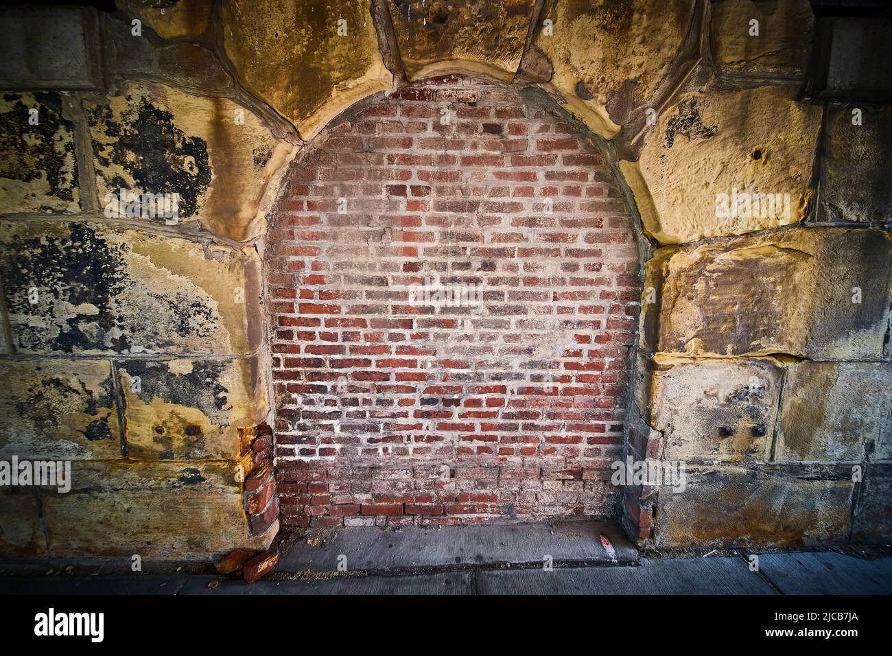 Stone archway eerie filled in with red brick wall Stock Photo - Alamy