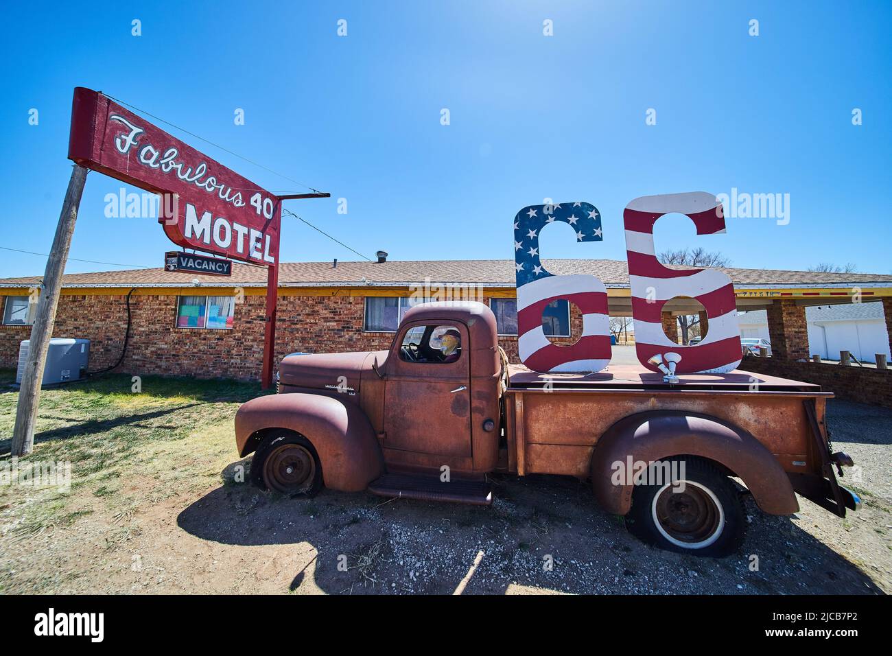 Old truck on Route 66 with American Flag pattern in sign by motel Stock ...