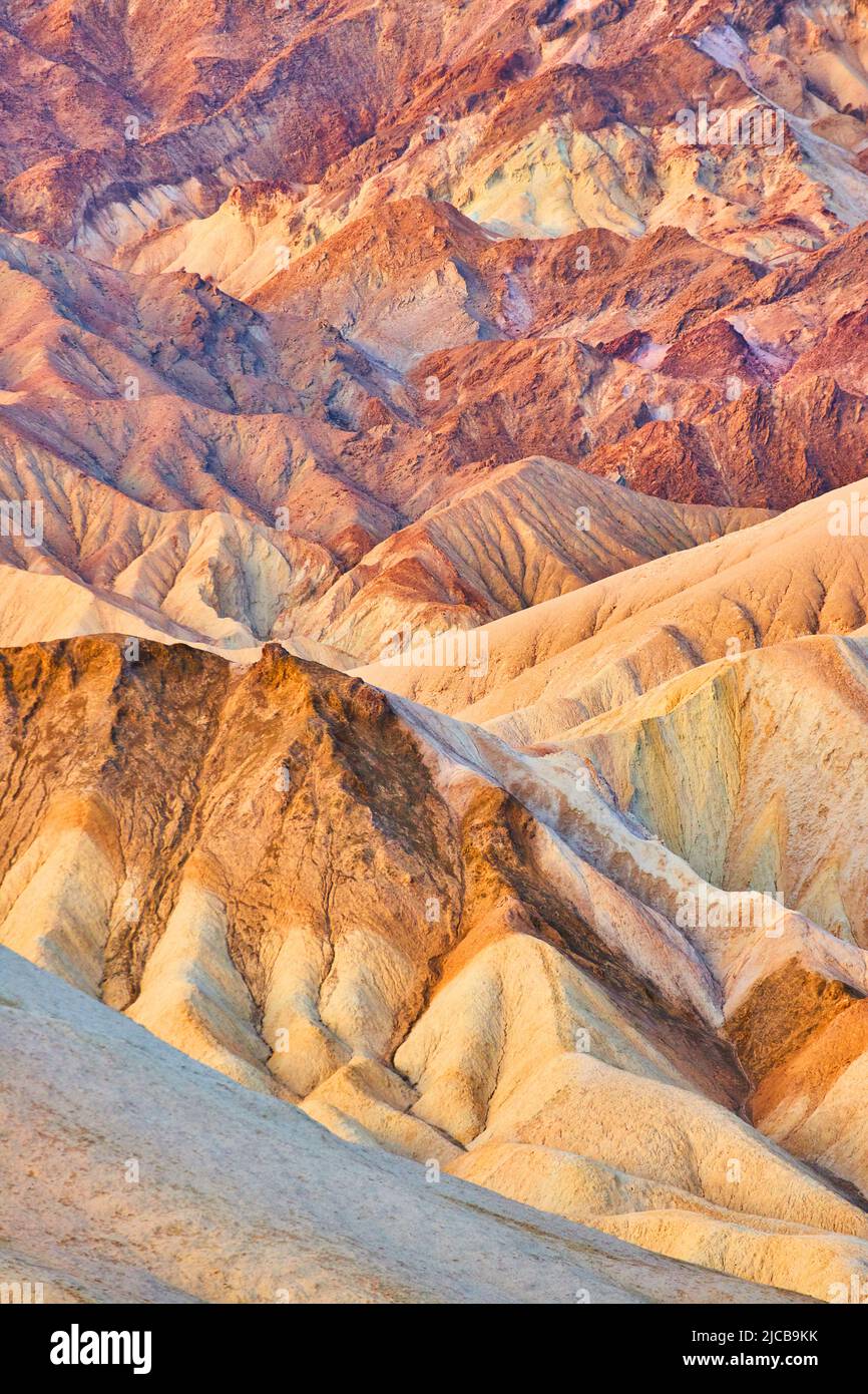 Sunrise showcases layers of stunning colors in eroded sediment at Death ...