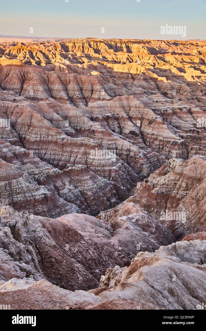 South Dakota Badlands filling slowly with sunlight over sediment layers ...