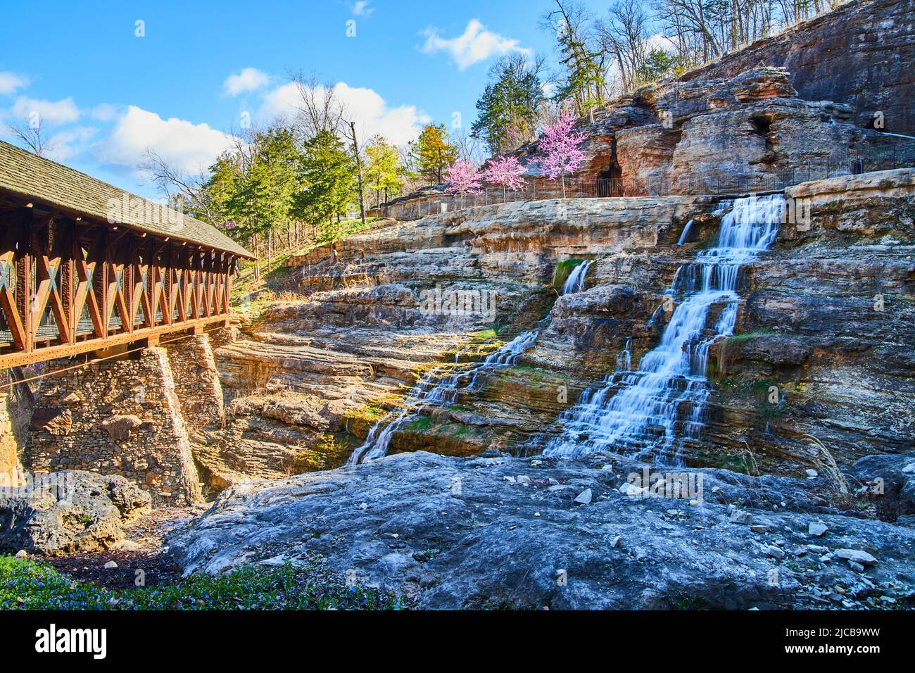 Stunning waterfalls cascading down into valley under wood bridge in ...