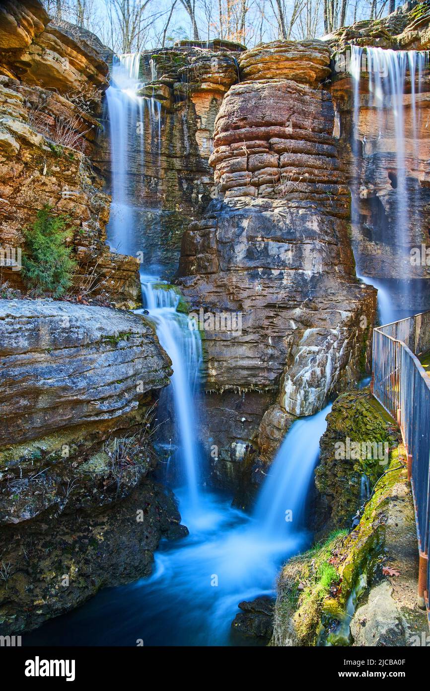 Long exposure of small waterfalls through cliffs next to path Stock ...