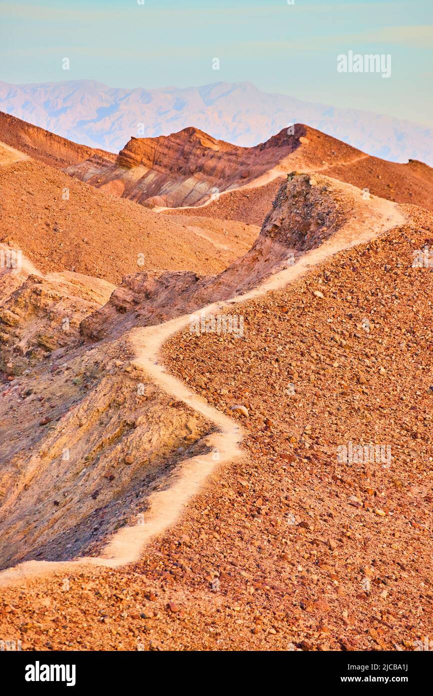 Narrow dirt hiking path follows ridge of mountain top in desert Stock ...