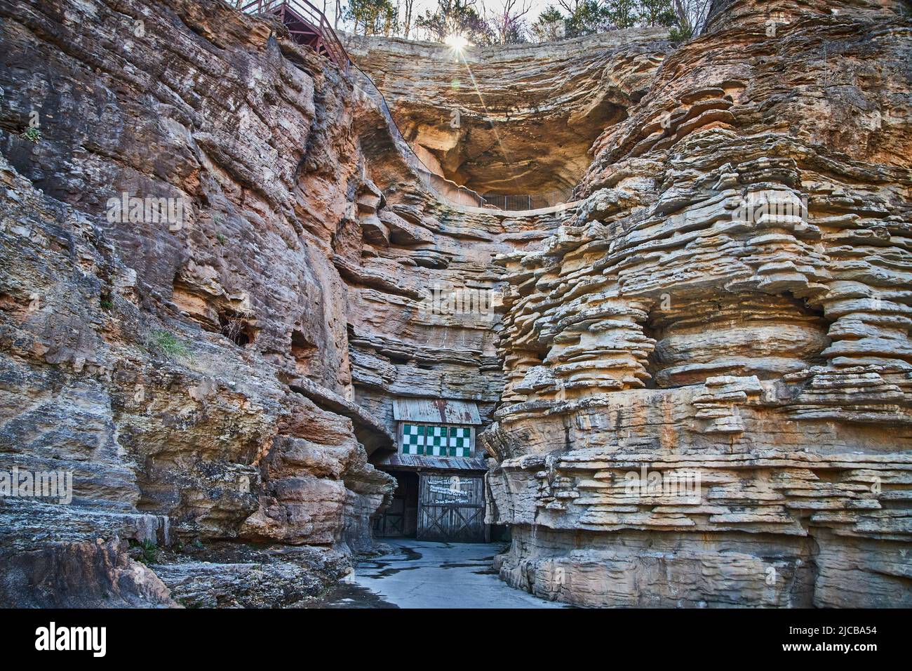 Paved path into cave lined with layers of rocks in cliffs Stock Photo ...