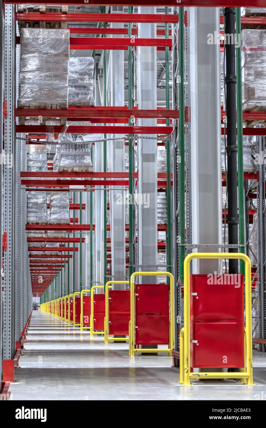 Lifting equipment with cargo near high shelving in storage Stock Photo ...