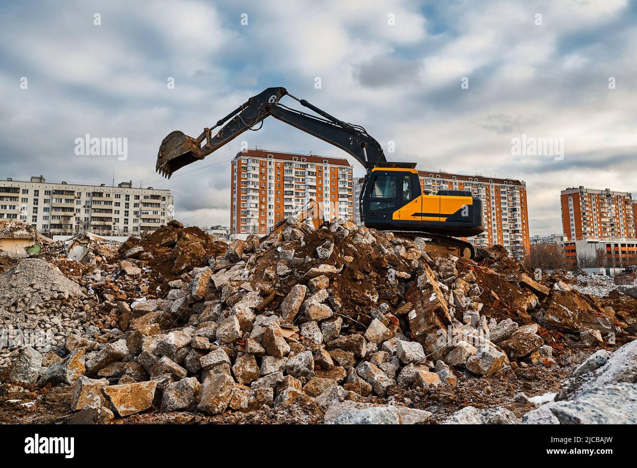 Excavator pours soil on pile of garbage at demolition site Stock Photo ...