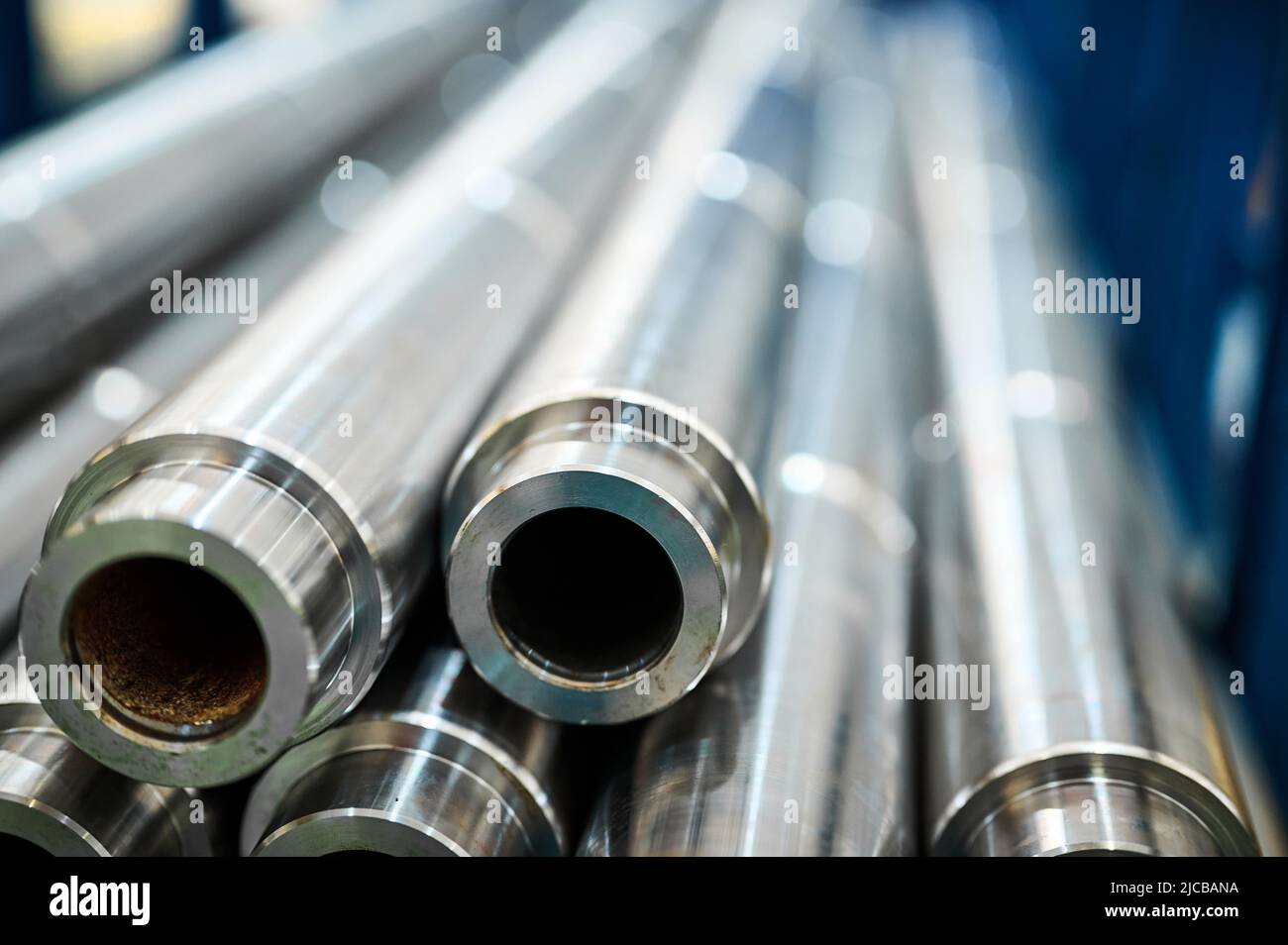 Pile of long drill rods metal workpieces in light warehouse Stock Photo ...