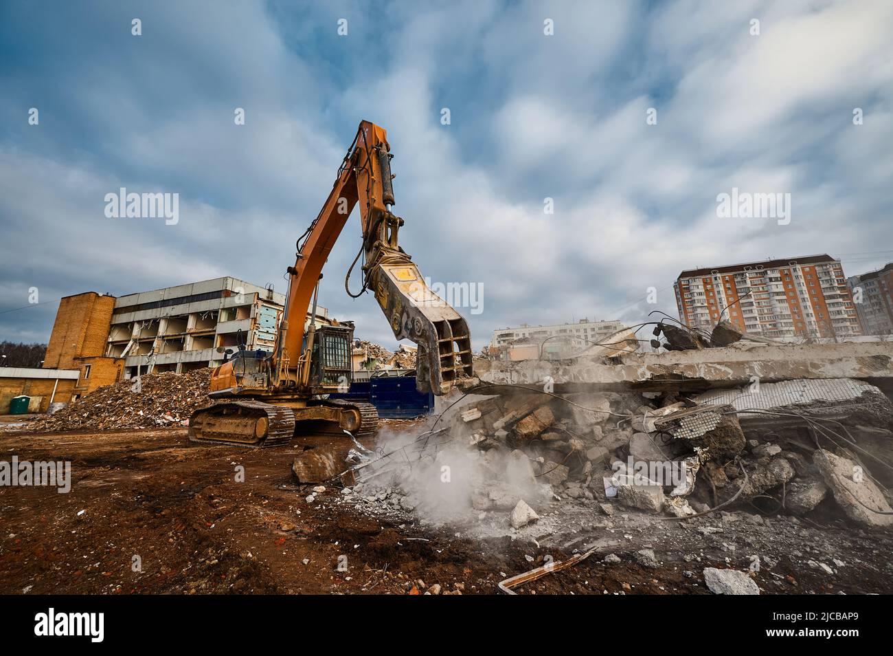 Excavator with hydraulic press breaks concrete leftovers Stock Photo - Alamy