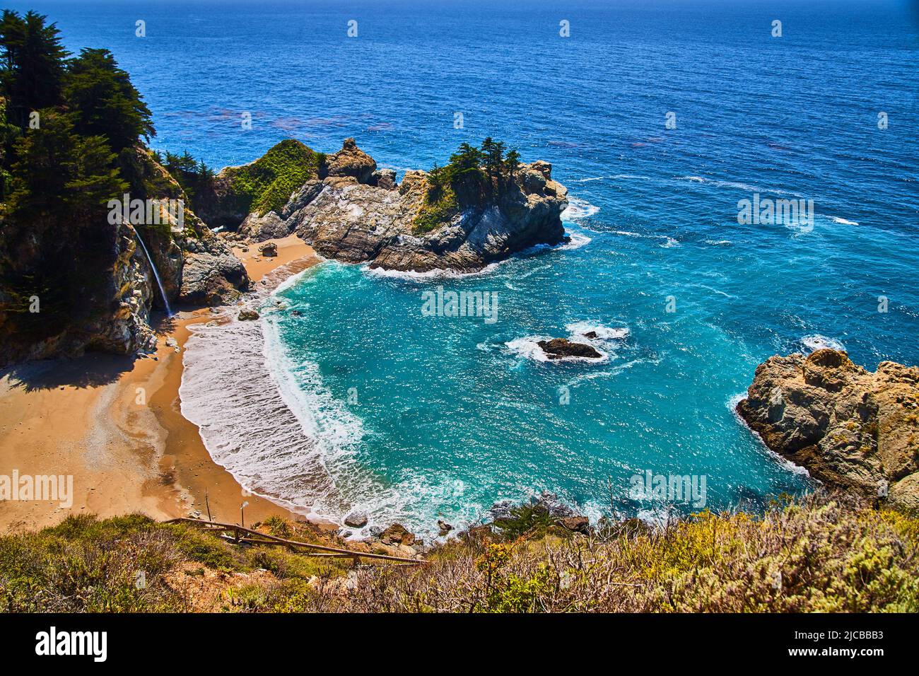 Ocean cove leads to sandy beaches and secret waterfall Stock Photo - Alamy