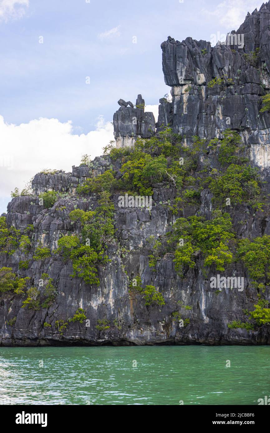 Mountain silhouette of the coast of Langkawi, Malaysia. Rocks overgrown ...