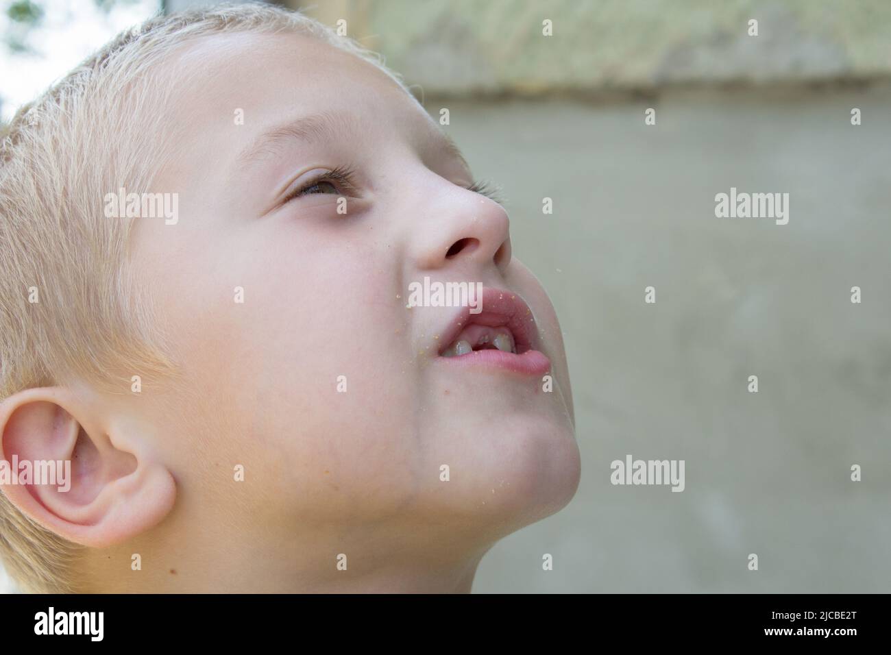 blond boy with a raised head looking up Stock Photo - Alamy