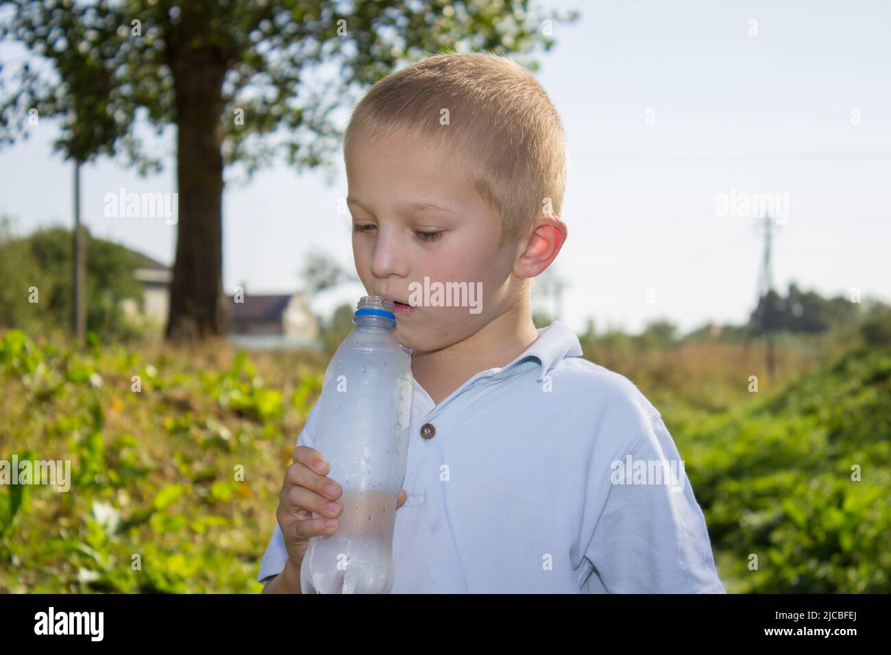 child wants to drink from a bottle of mineral water in the heat Stock ...