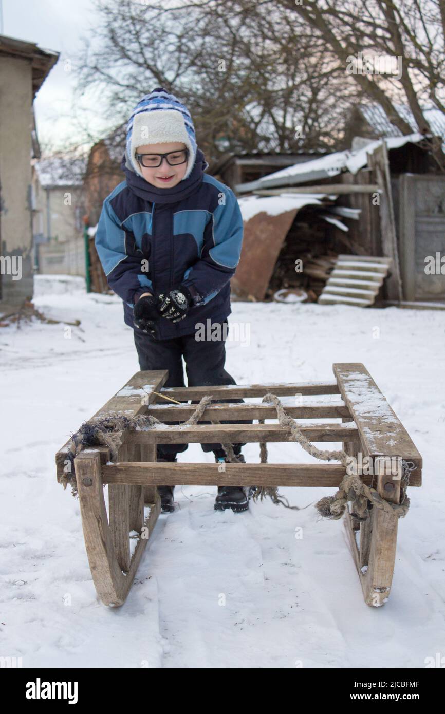 Boys playing in really big snow.big sled and a boy Stock Photo - Alamy