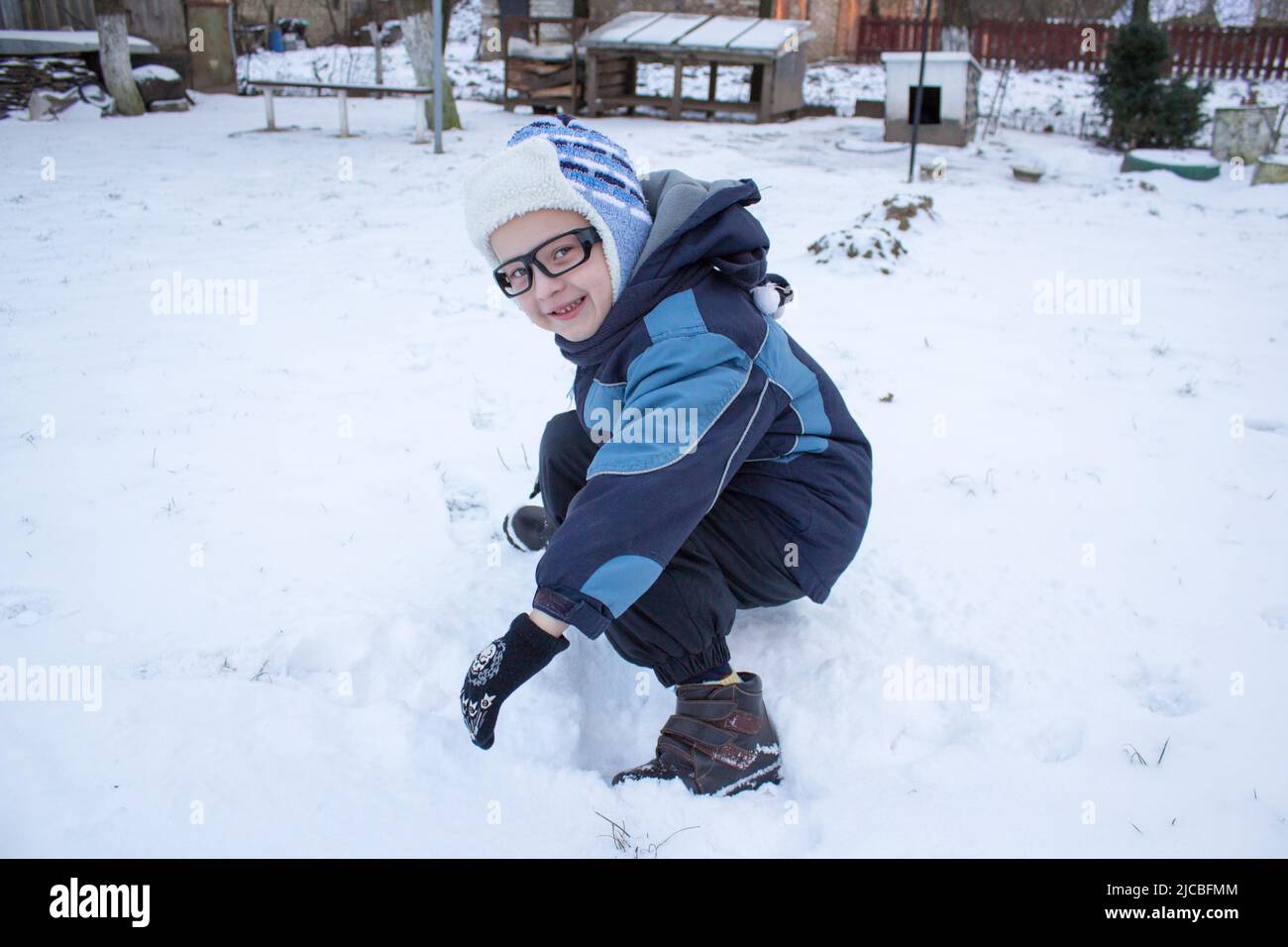cold winter boy crouched in the snow Stock Photo - Alamy