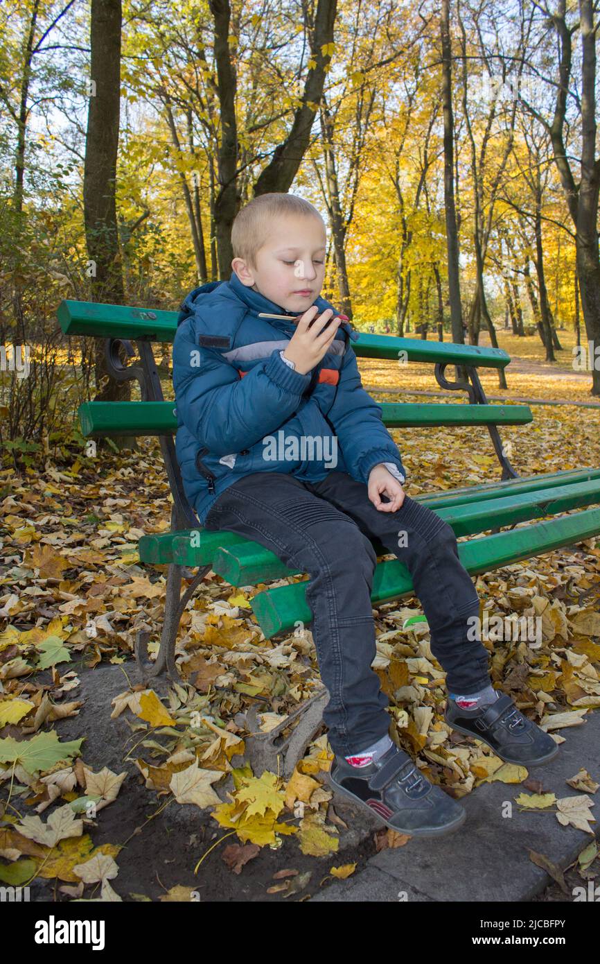 sitting in the park autumn boy on bench Stock Photo - Alamy