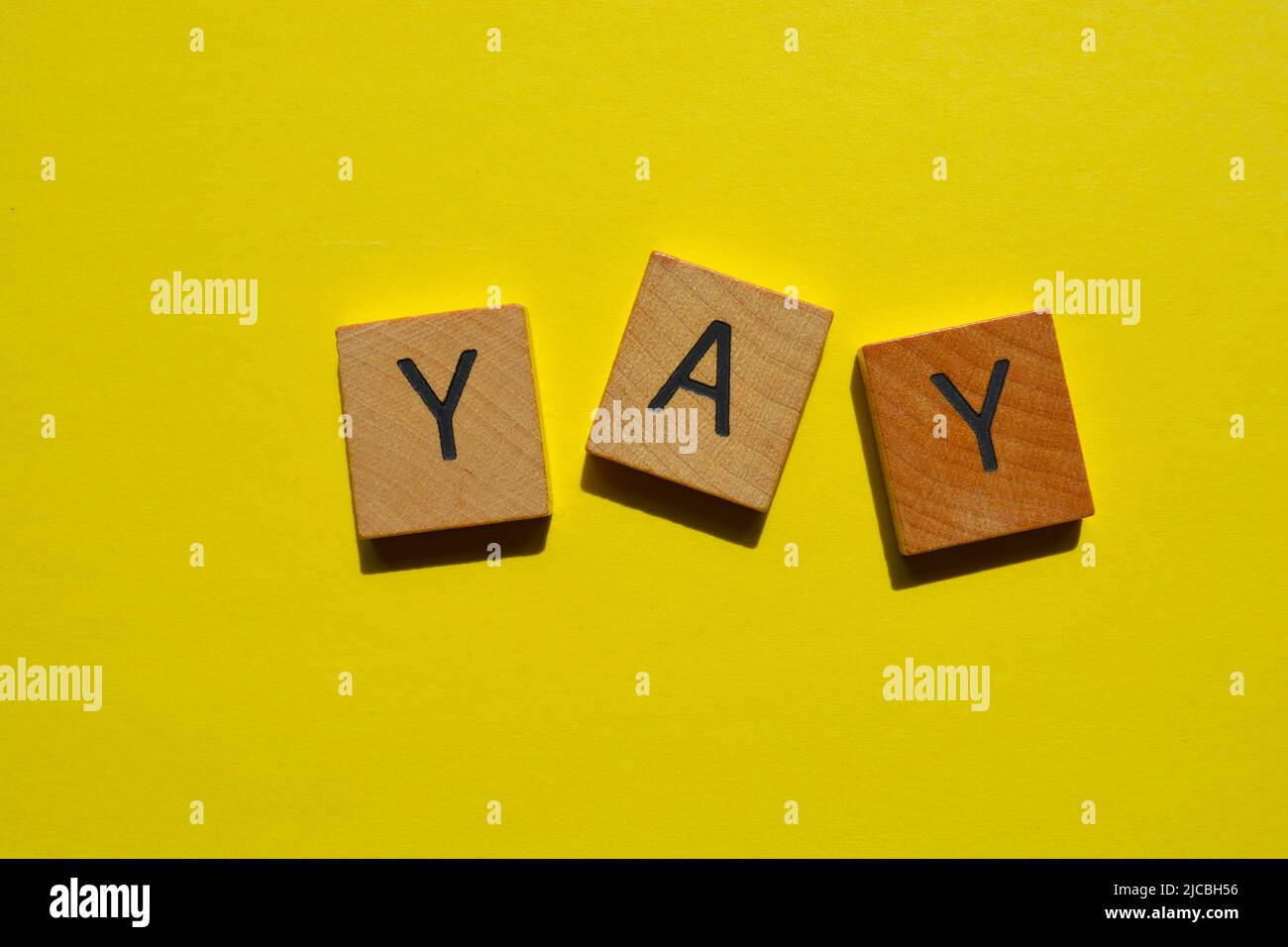 Yay, word in wooden alphabet letters isolated on bright yellow ...