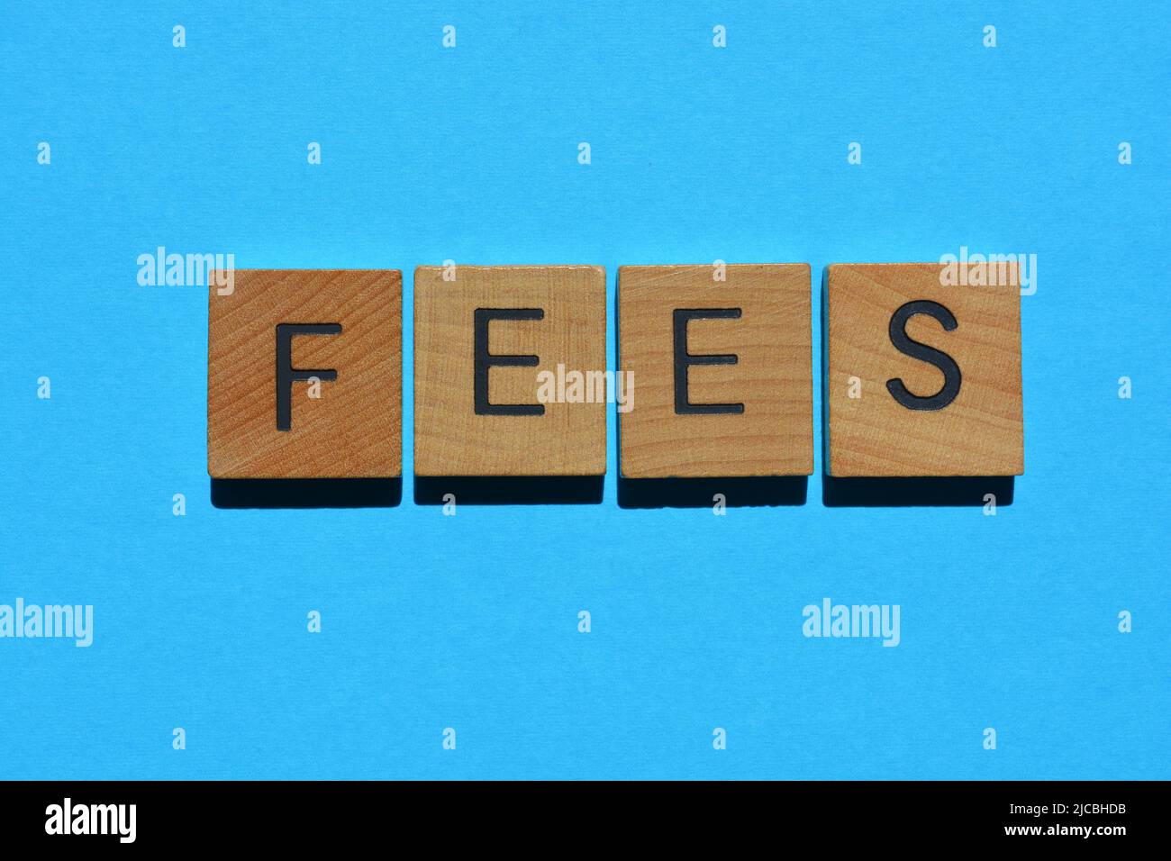 Fees, word in wooden alphabet letters isolated on blue background Stock ...