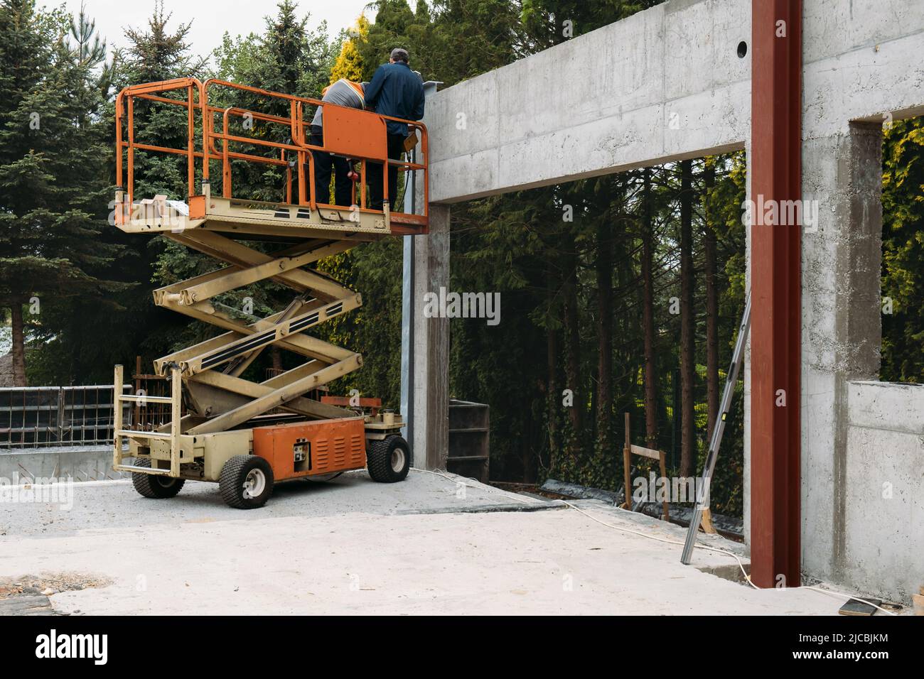 Scissor Lift Platform with workers on a construction site. Building ...