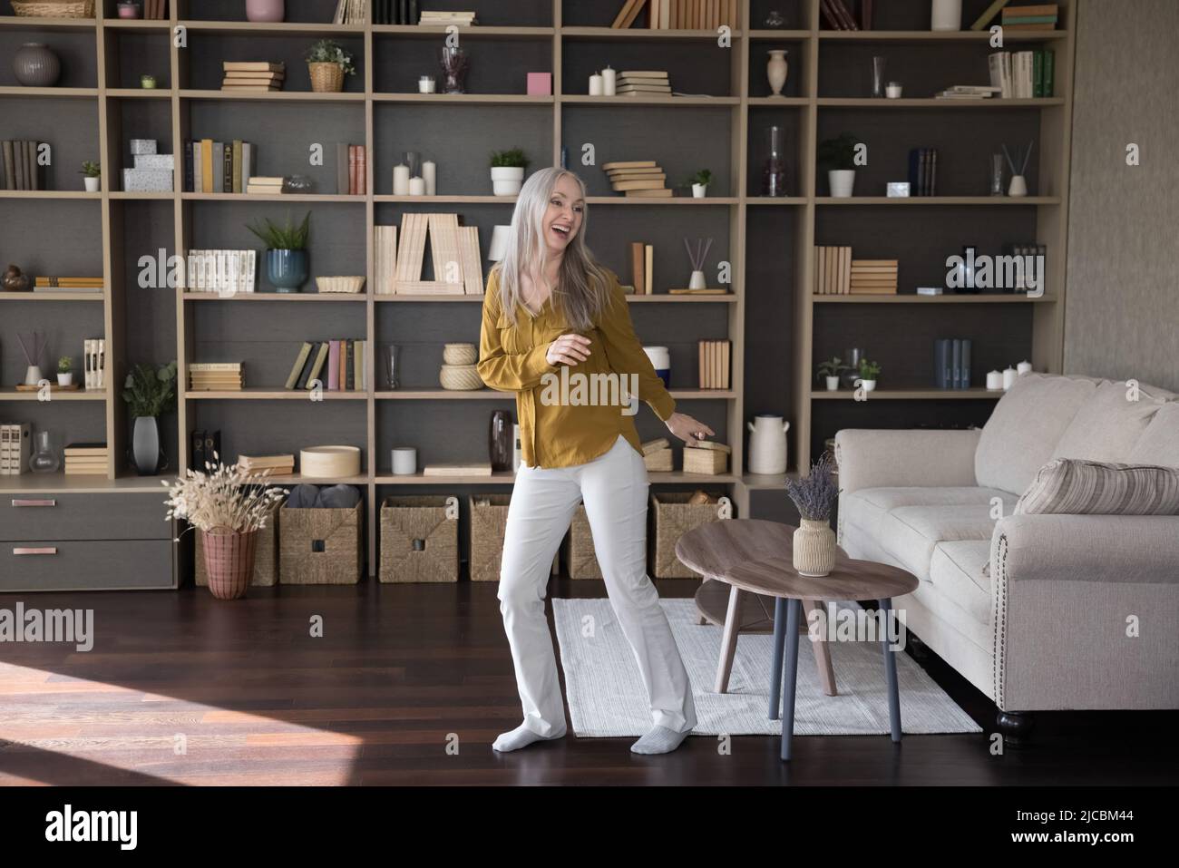 Active middle-aged woman dance in modern living room Stock Photo - Alamy