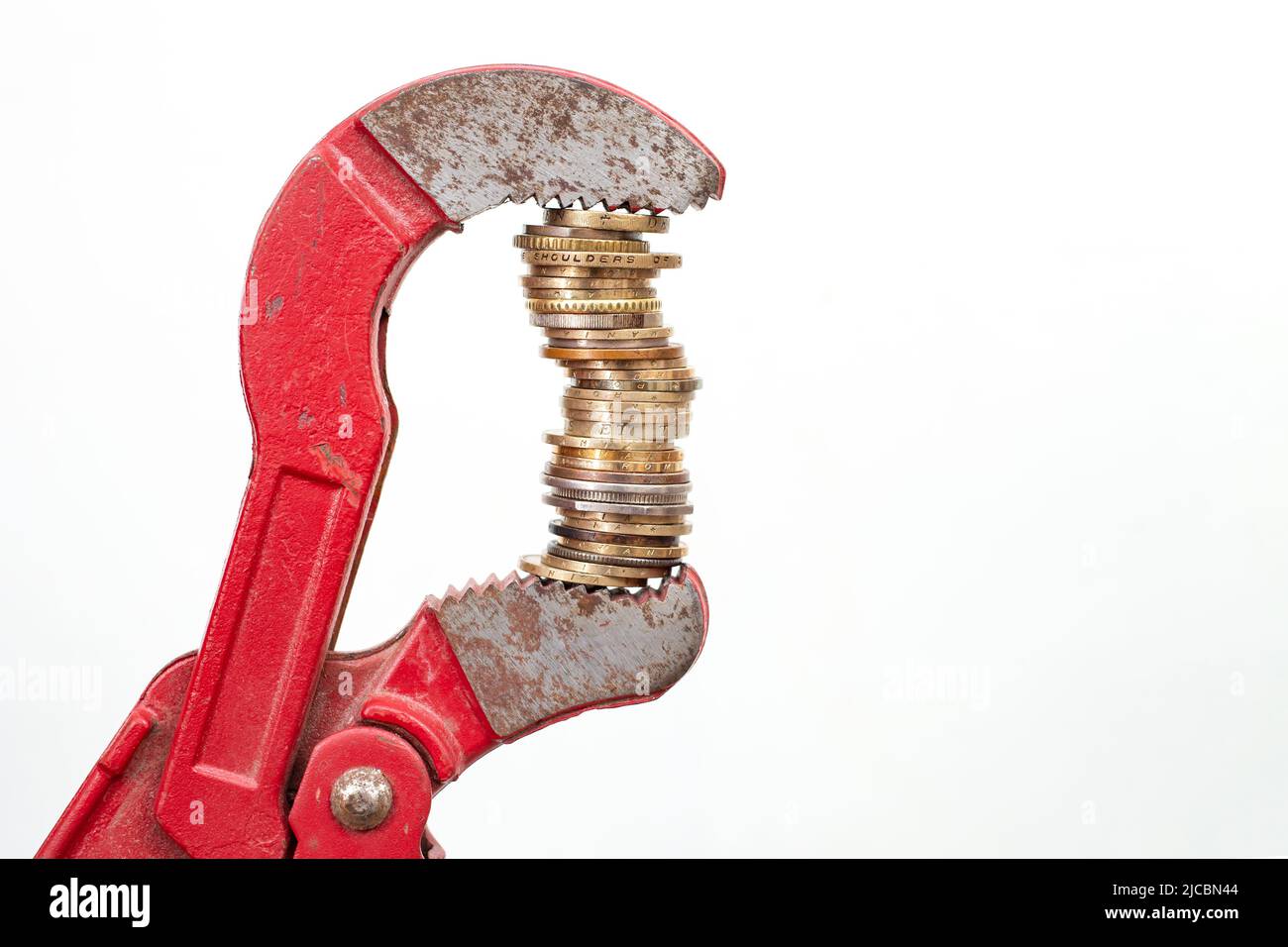 Pipe wrench squeezing a high stack of coins, isolated on white ...
