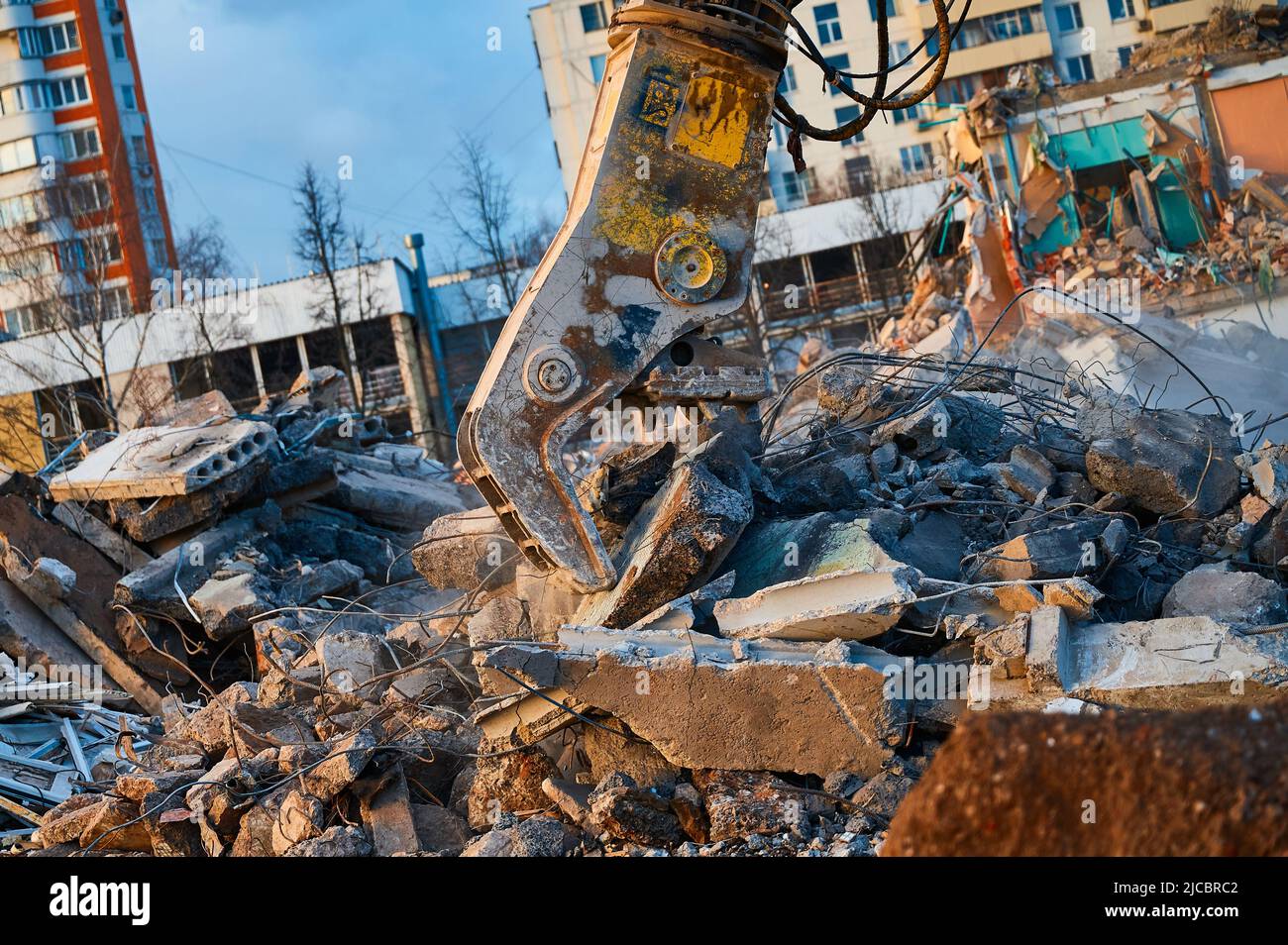 Crusher destroys reinforced concrete at demolition site Stock Photo - Alamy