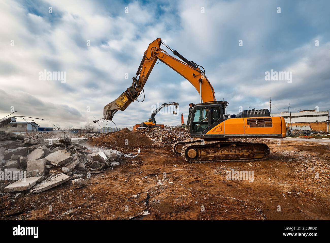 Excavator destroyer with hydraulic scissors cuts concrete Stock Photo ...